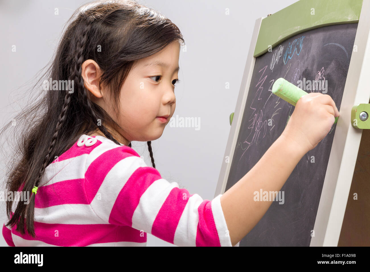 Young girl writing on blackboard on white background Stock Photo - Alamy