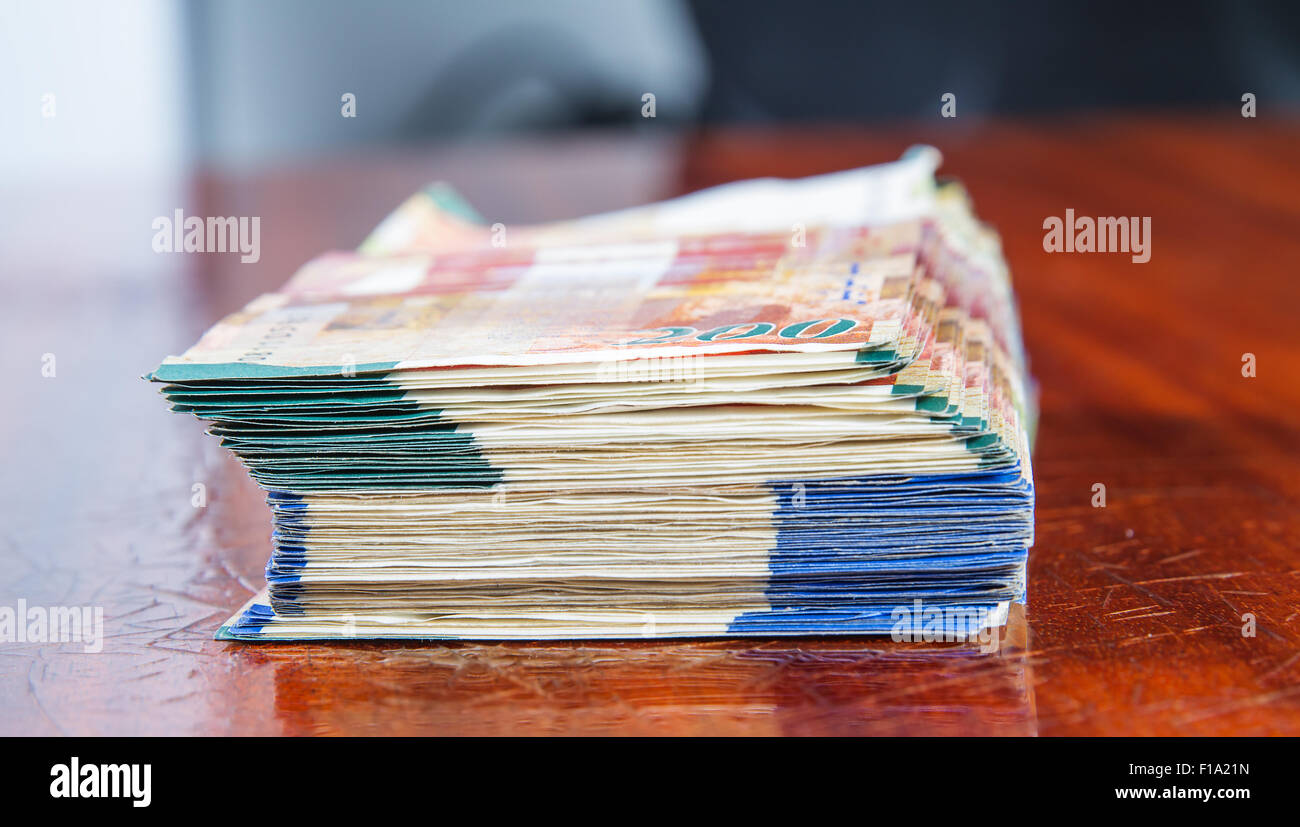 Two hundred and one hundred shekel bank notes against wood background ...