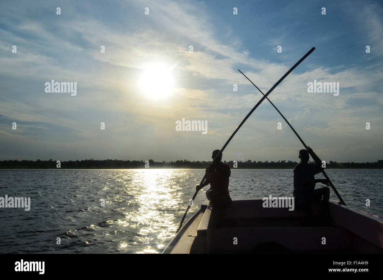 Two African men navigating on lake Doukon in Benin with sticks Stock ...