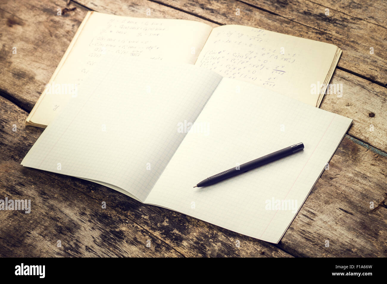 School notebook with pen on old wooden table. Exersice book of physical ...