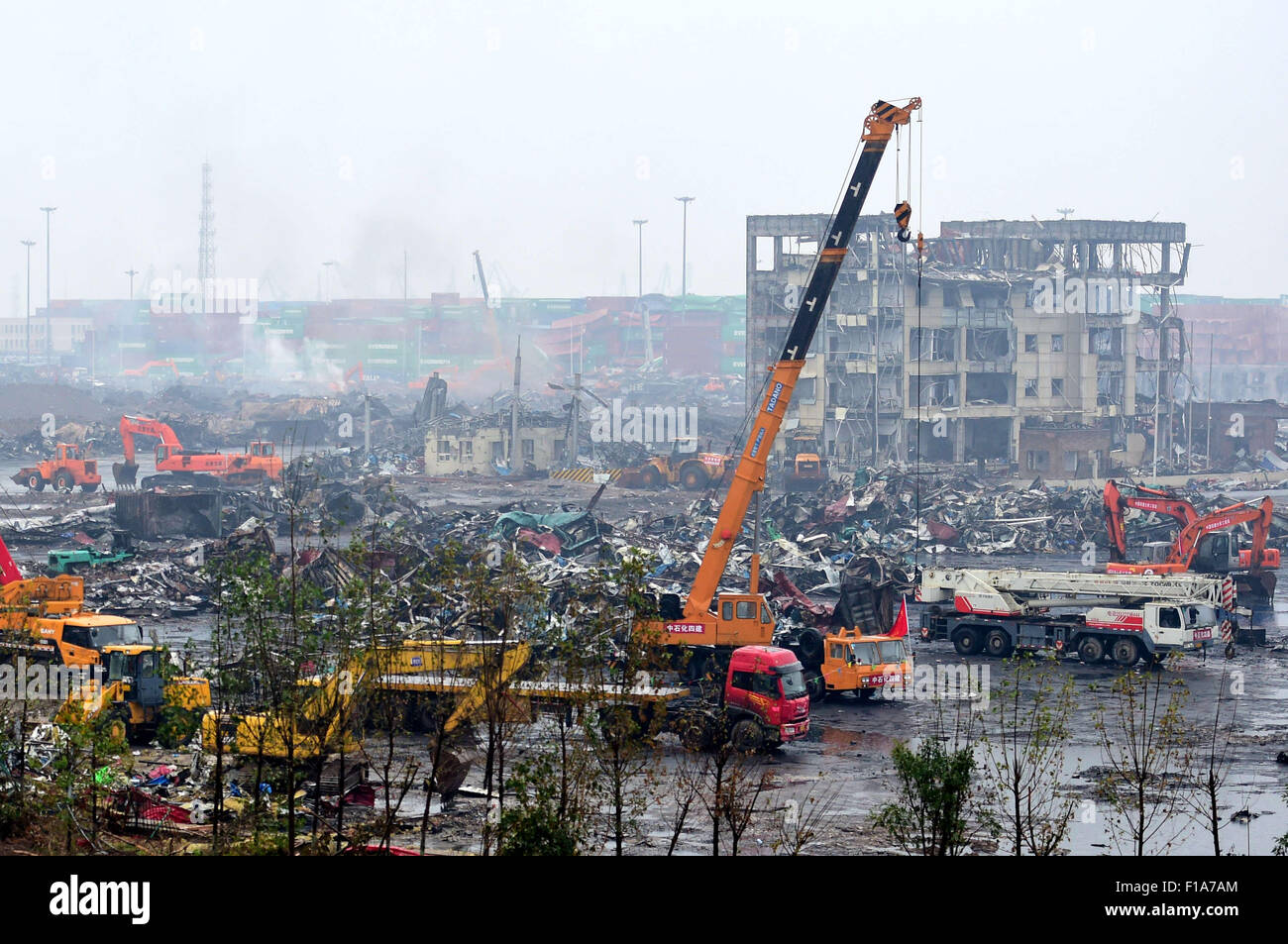 Tianjin, China. 31st Aug, 2015. Rescuers clean up debris at the ...