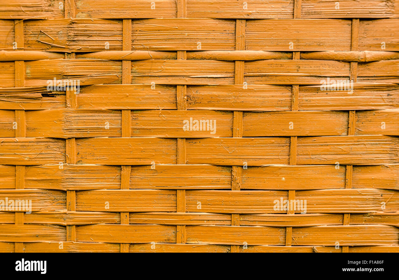 Close-up of orange painted natural bamboo wood strips woven background ...