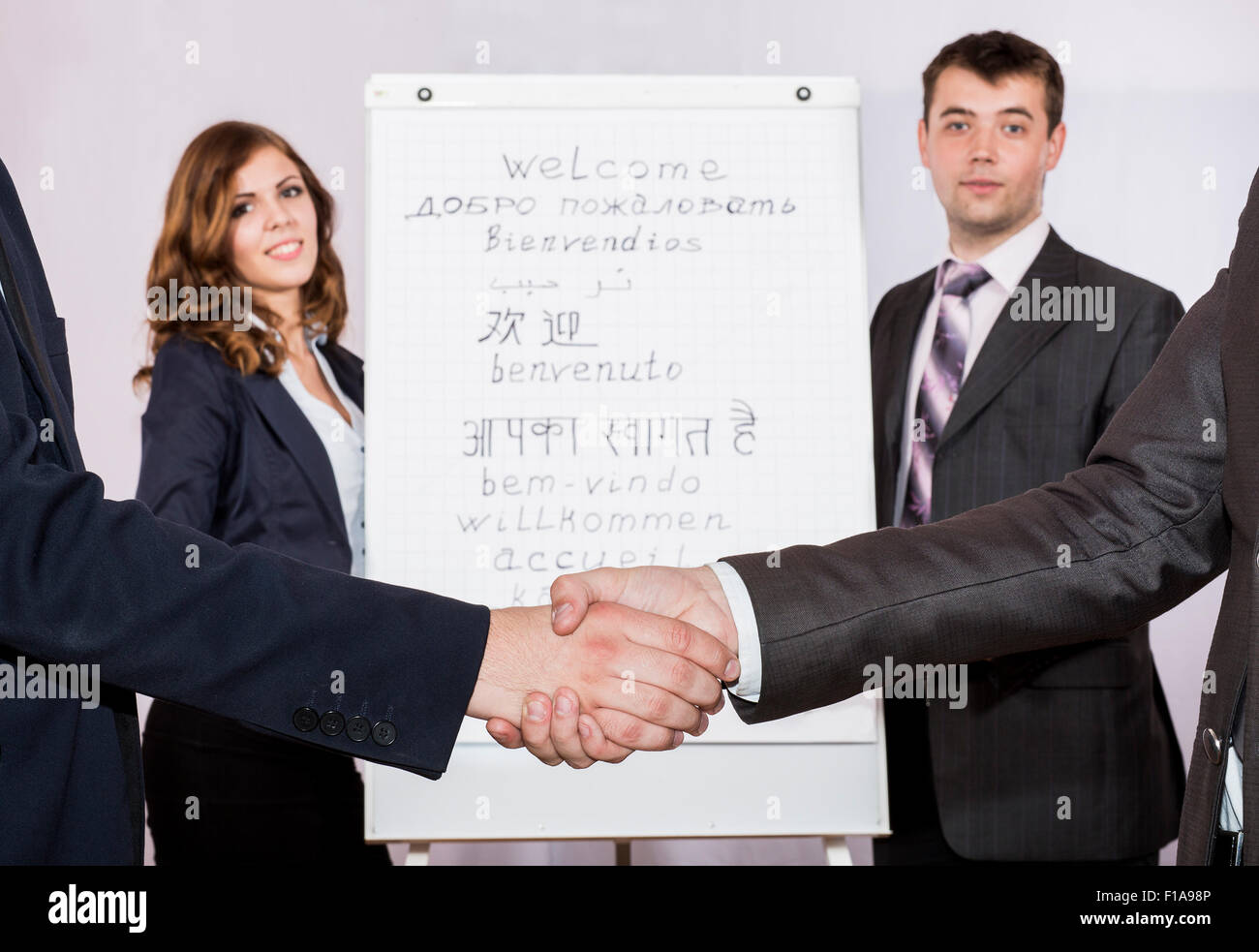 Two young corporate trainers welcome participants of the training Stock ...