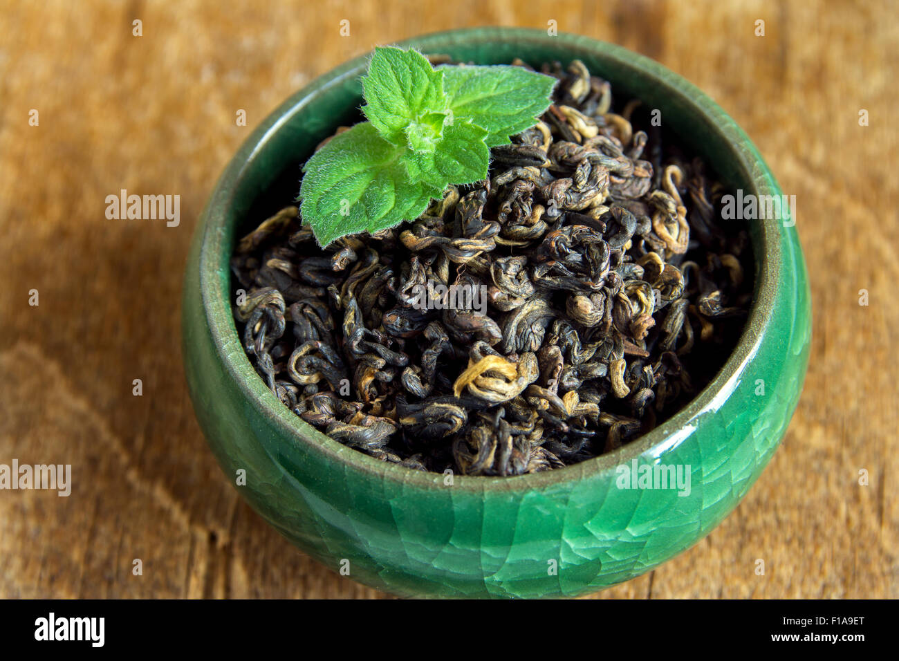 Elite dried chinese black tea with mint in cup over rustic wooden ...