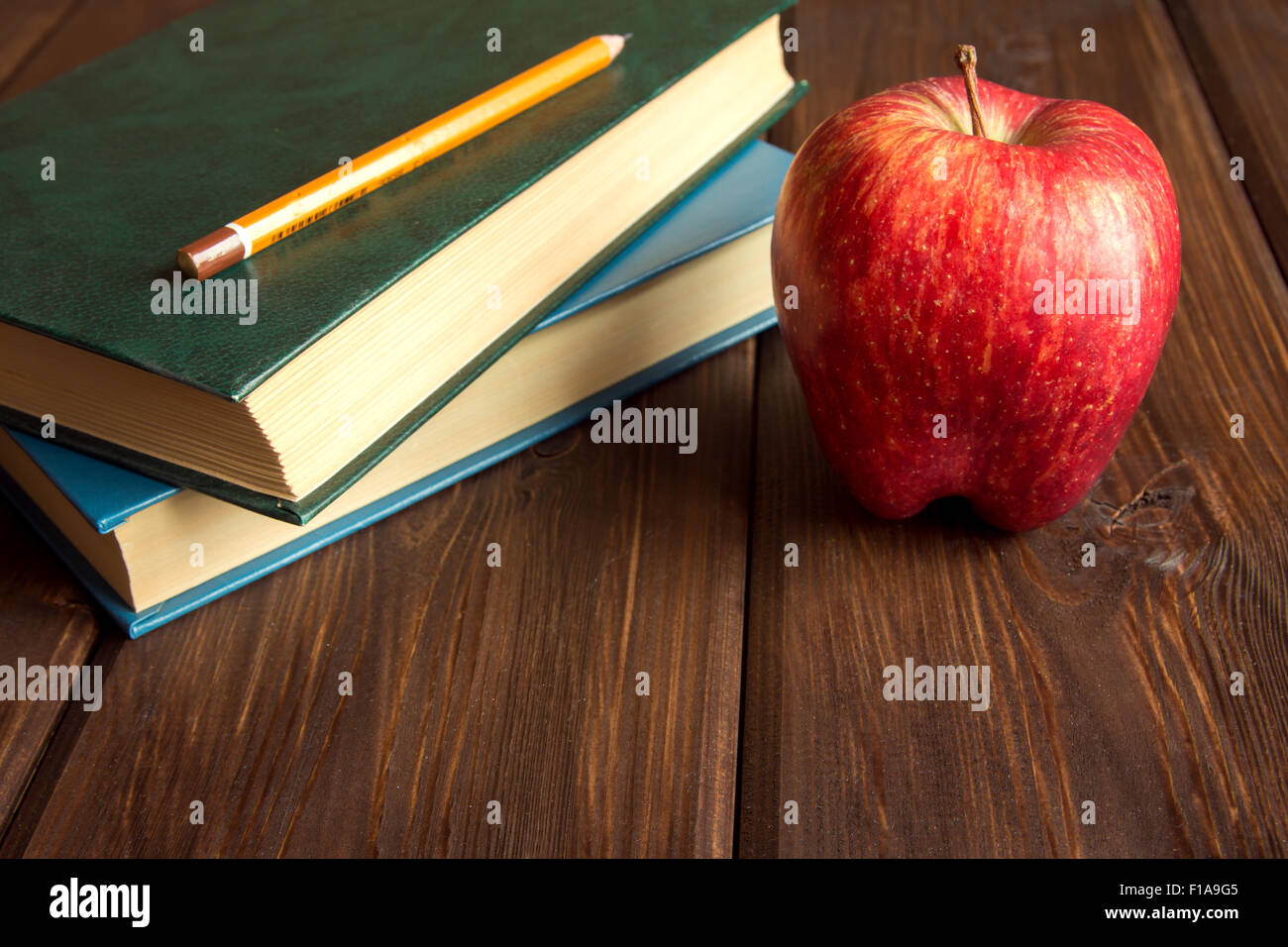 Old books and red apple on wooden background with copy space Stock ...