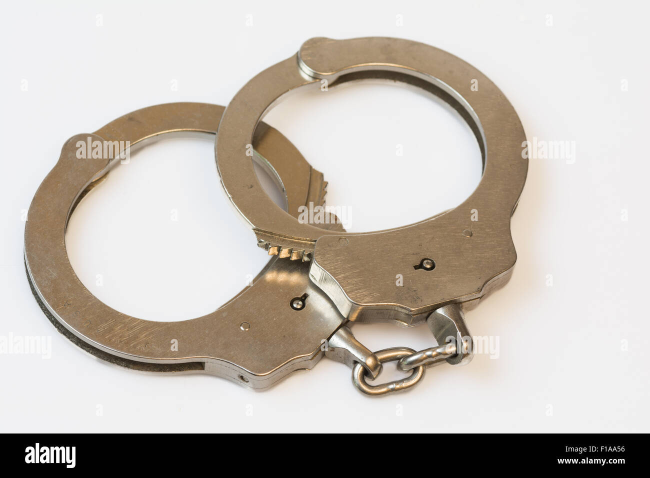 Handcuffs on white background Stock Photo - Alamy