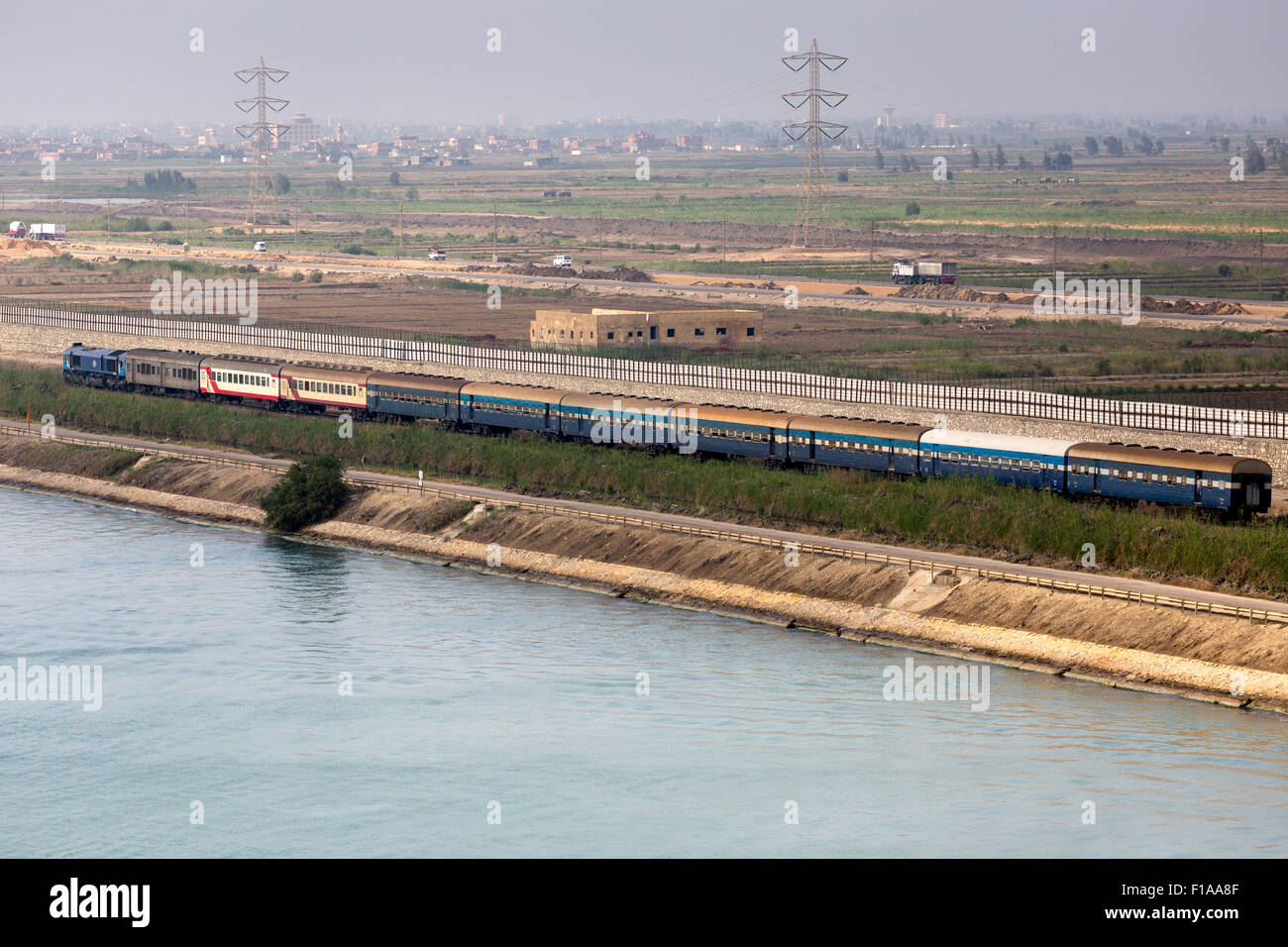 Early morning commuter train passing alongside Suez Canal Egypt Stock ...
