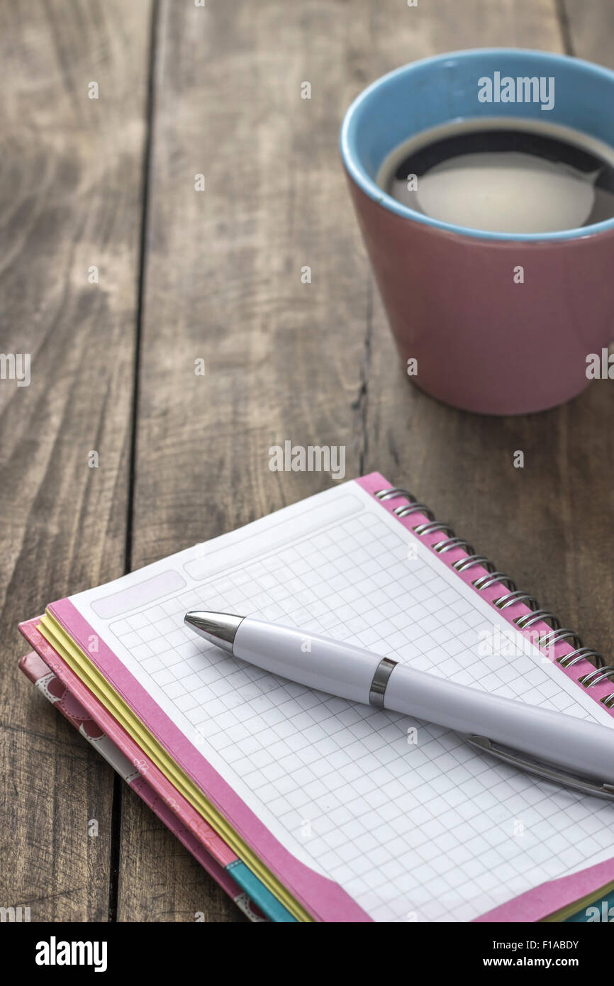 Notebook and coffee on wooden desk, close up Stock Photo - Alamy