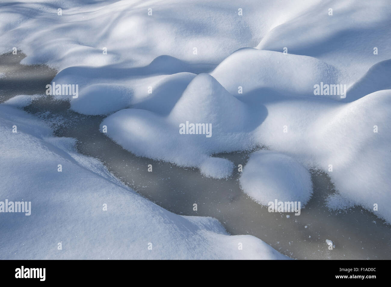 Snow Covered Rocks In Frozen Stream Stock Photo - Alamy