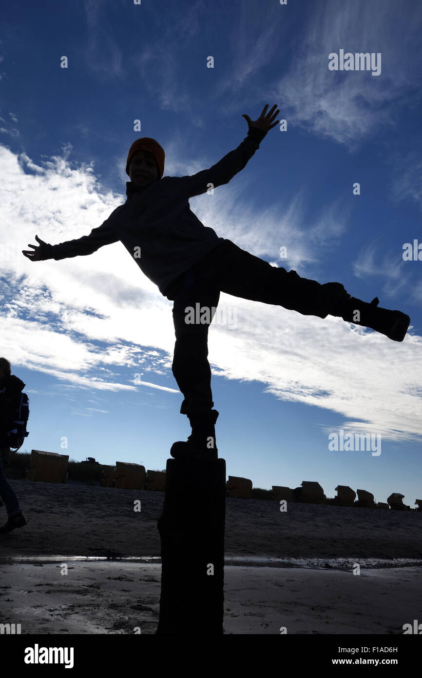 Wustrow, Germany, boy standing on one leg on a wooden post Stock Photo ...