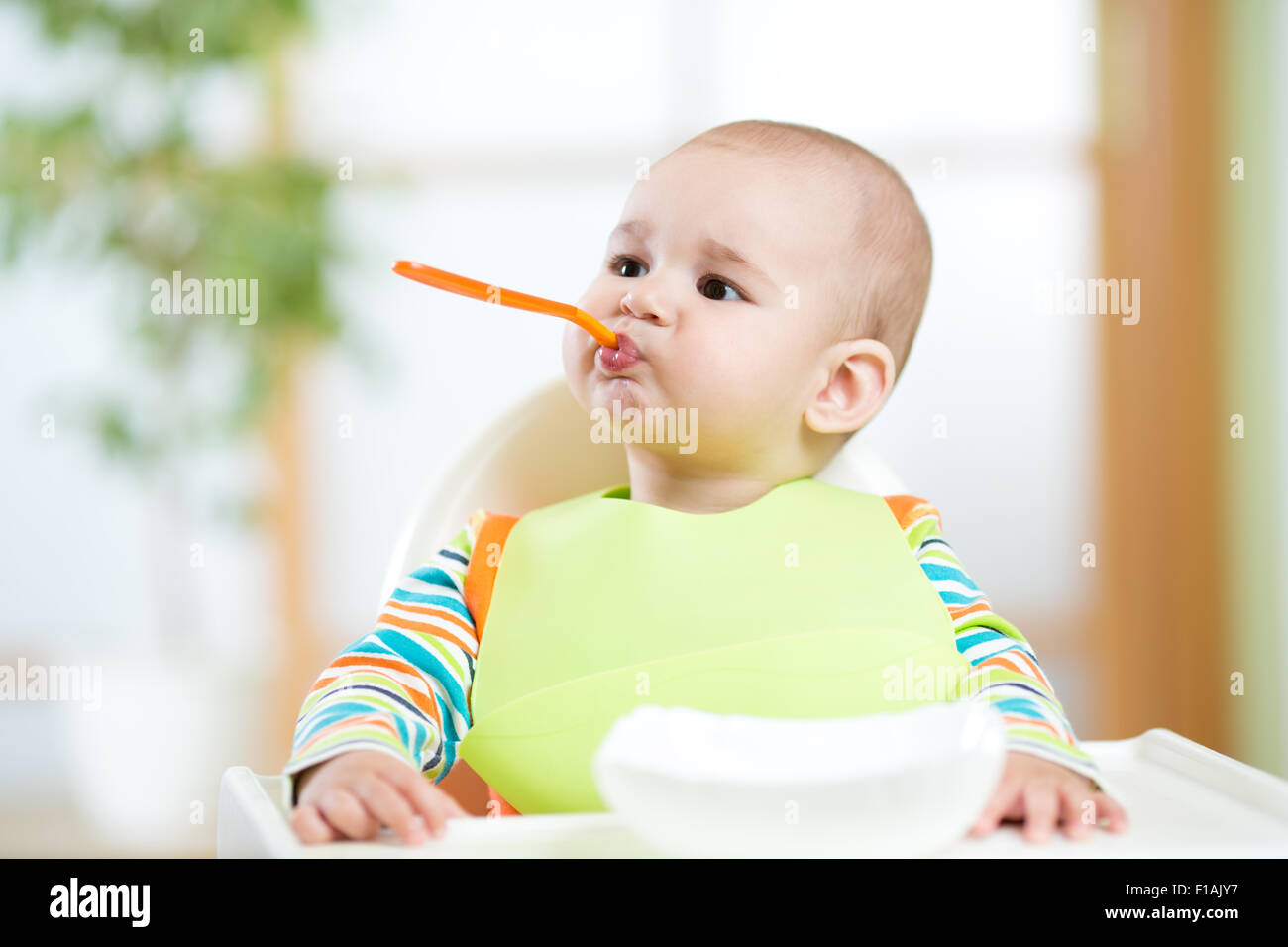 funny kid with spoon in mouth Stock Photo - Alamy