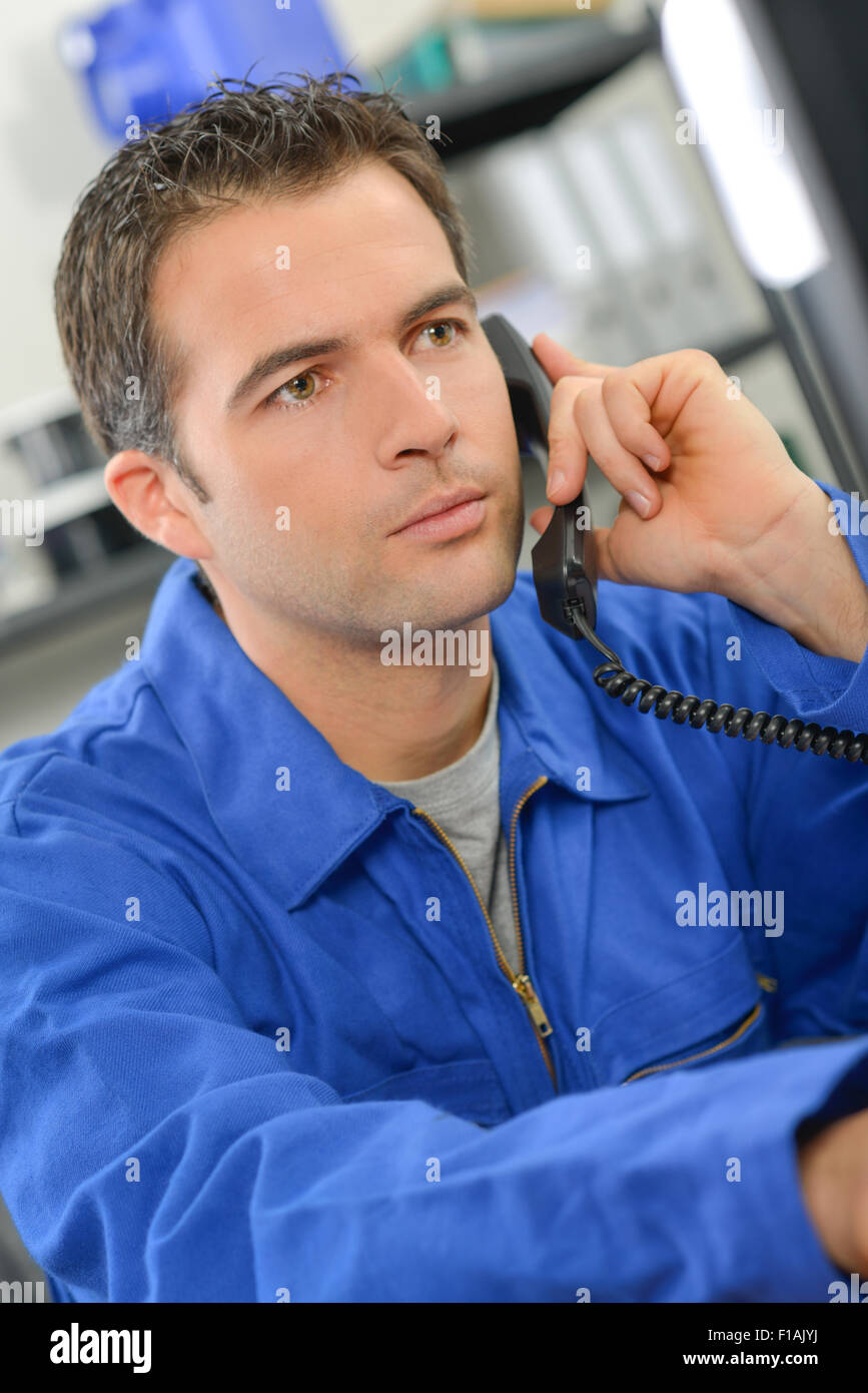Manual worker making a call in the office Stock Photo - Alamy