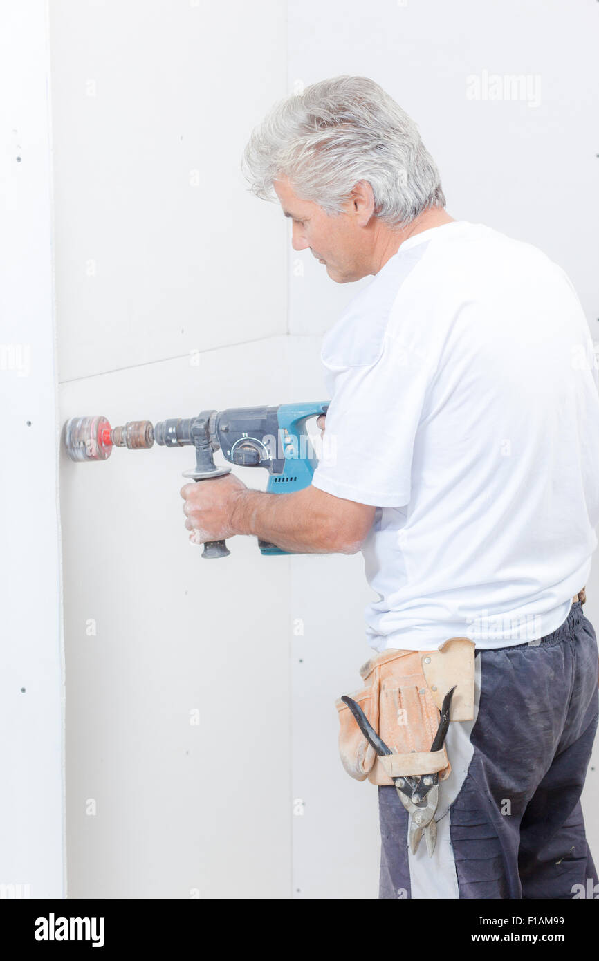 Builder using drill with attachment Stock Photo - Alamy