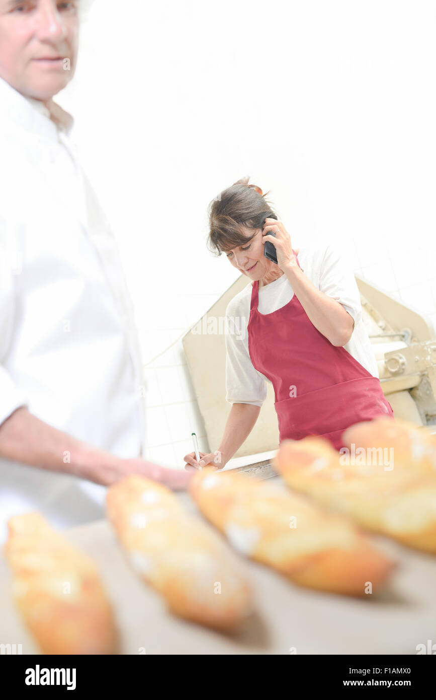 Baguettes, baker and shop assistant Stock Photo - Alamy