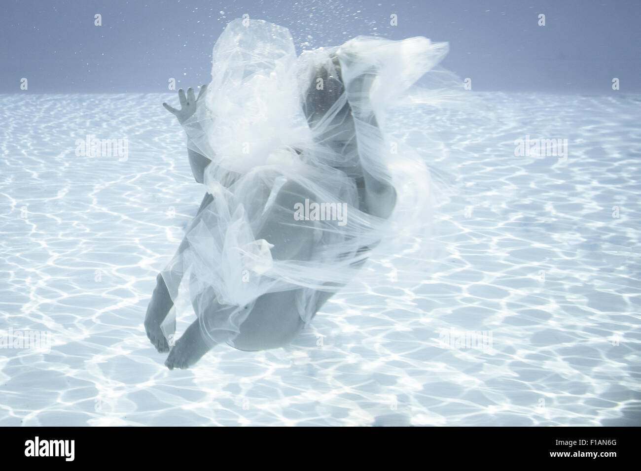 Young woman wrapped in cloth floating in water Stock Photo - Alamy