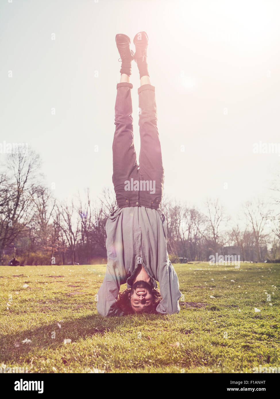 Young man doing headstand on a meadow Stock Photo - Alamy