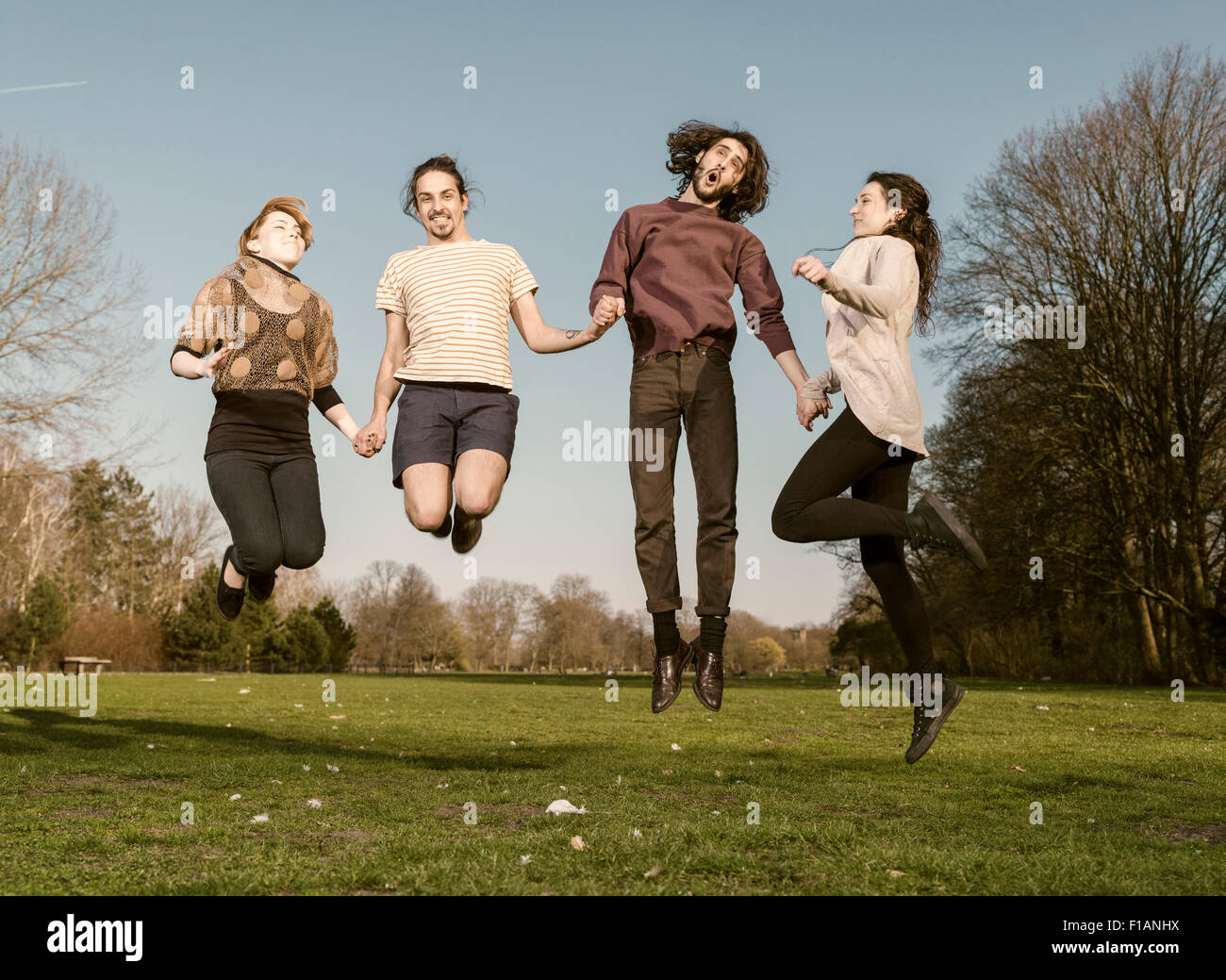 Four friends on a meadow jumping together in the air Stock Photo - Alamy