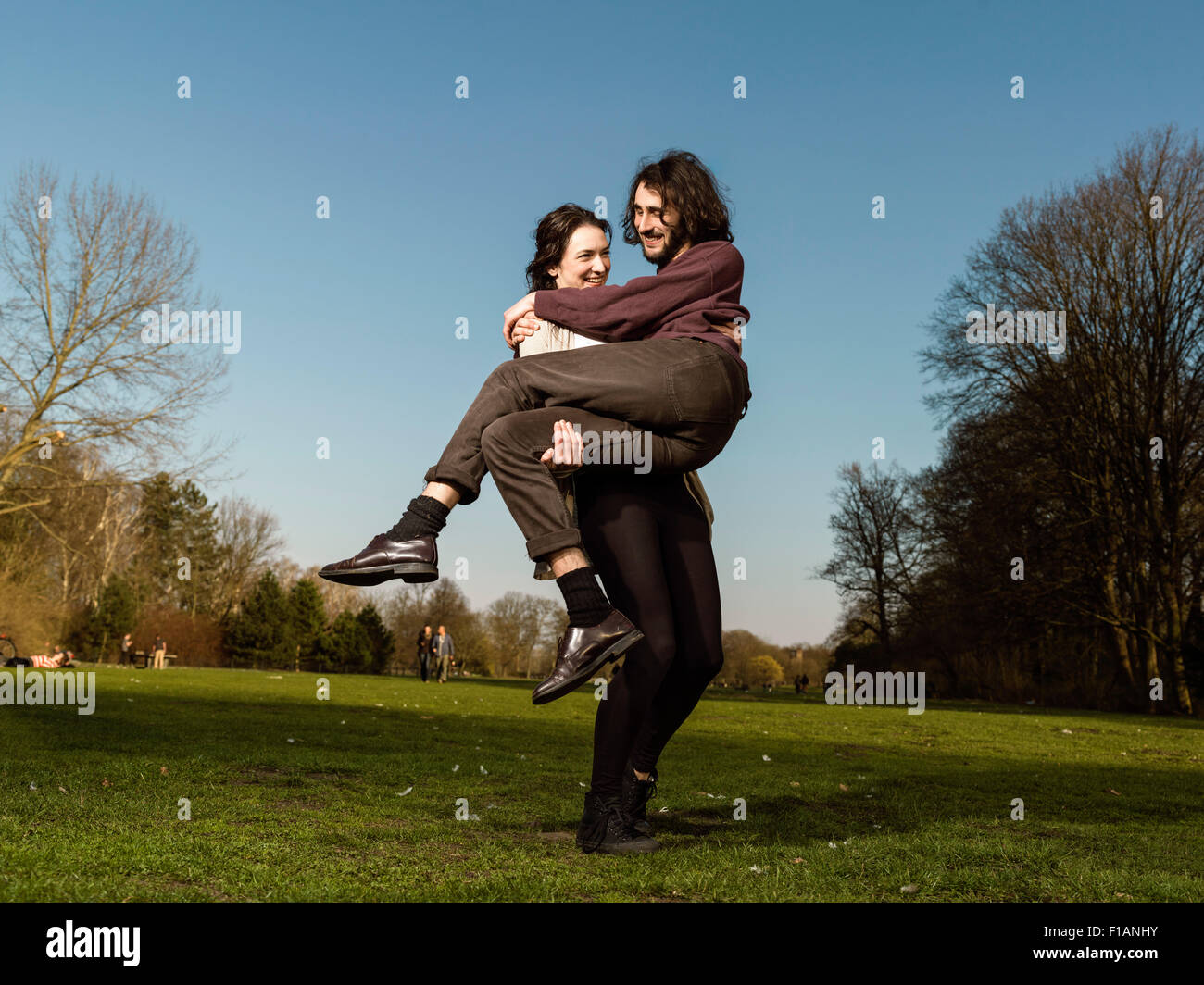 Young woman trying to carry her boyfriend Stock Photo - Alamy