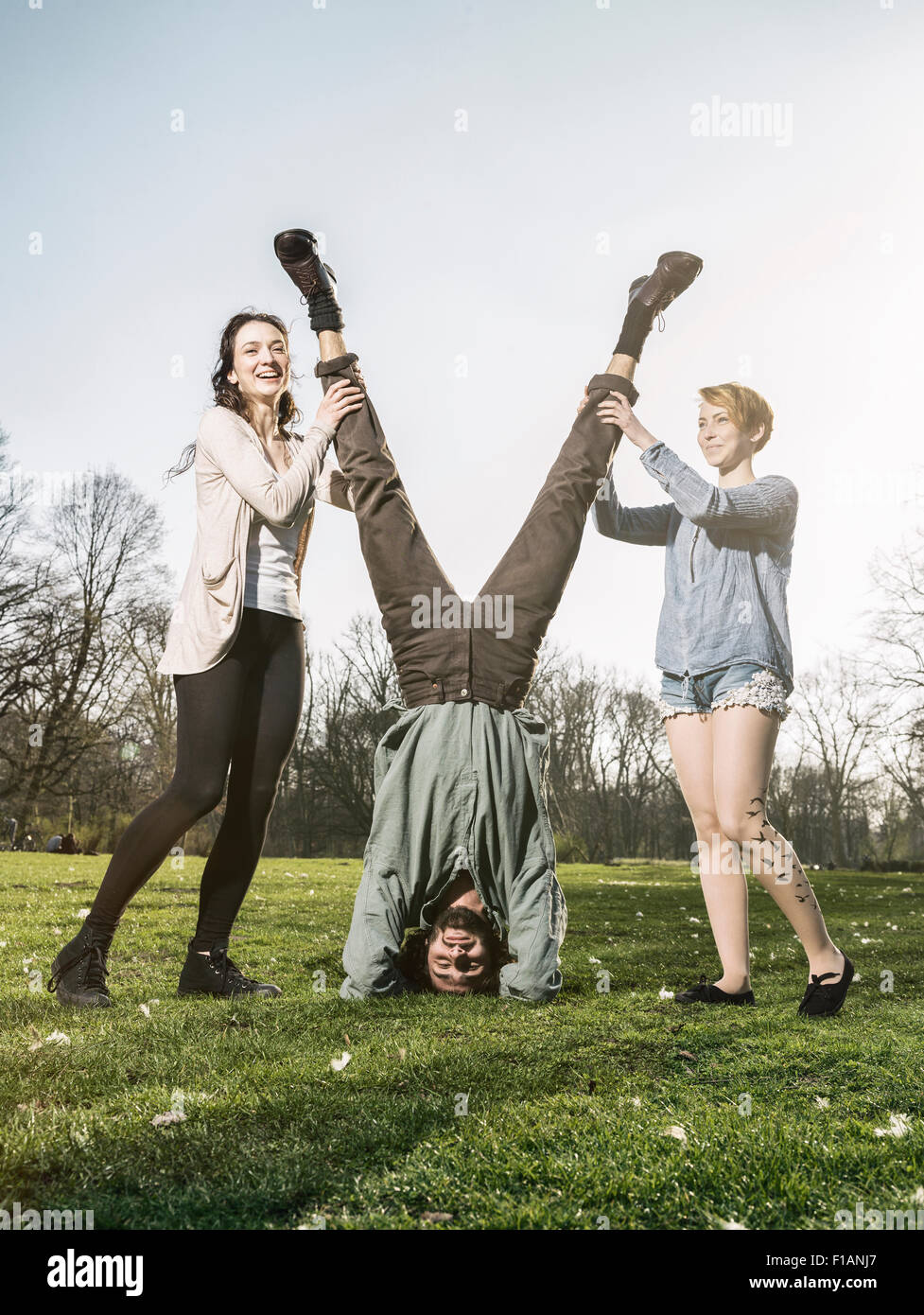 Three friends having fun on a meadow Stock Photo - Alamy