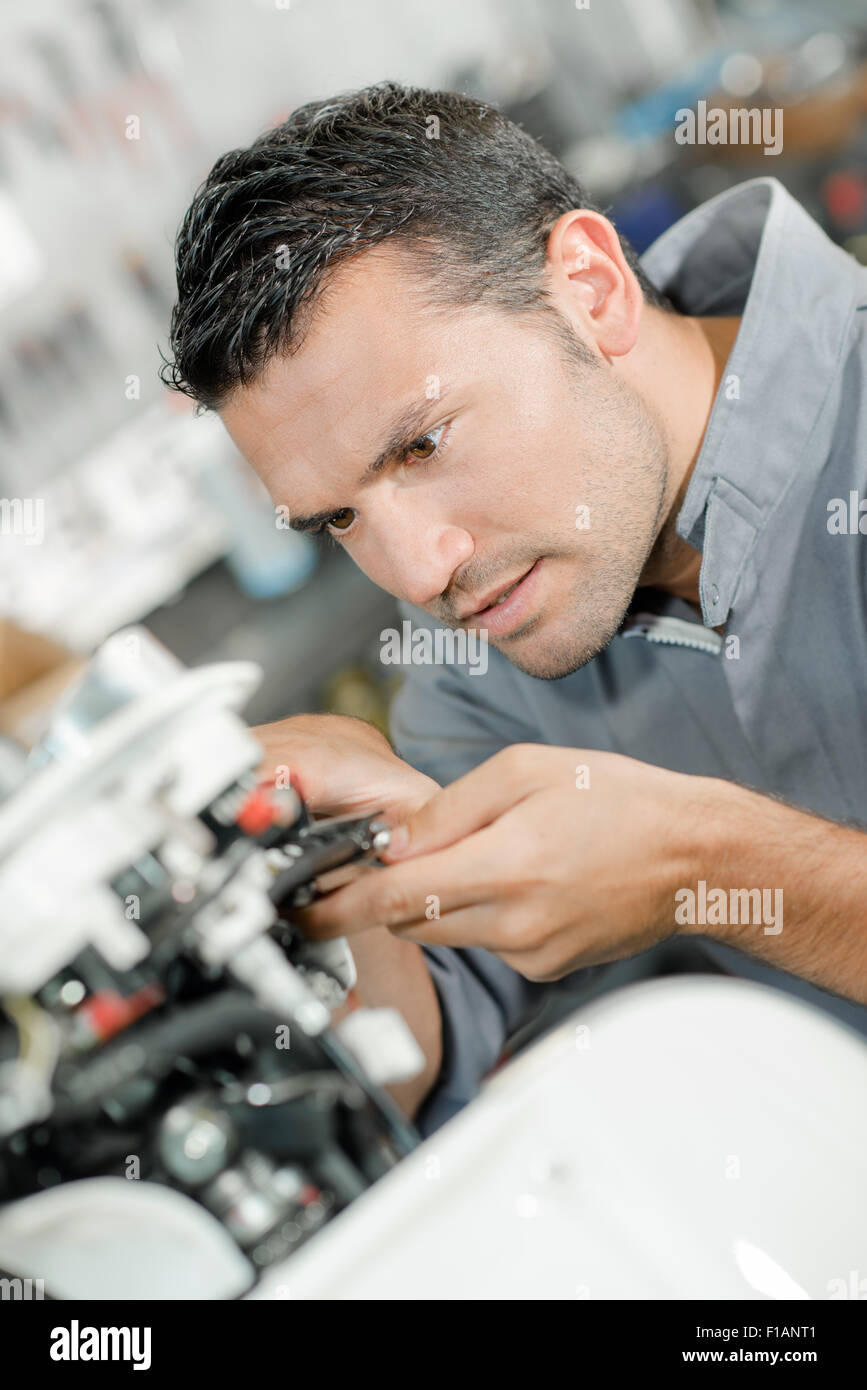 Mechanic examining a scooter Stock Photo - Alamy
