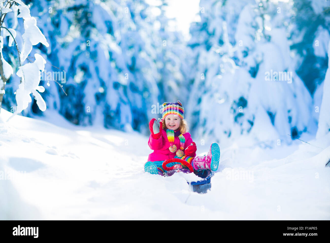 Little girl enjoying a sleigh ride. Child sledding. Toddler kid riding ...