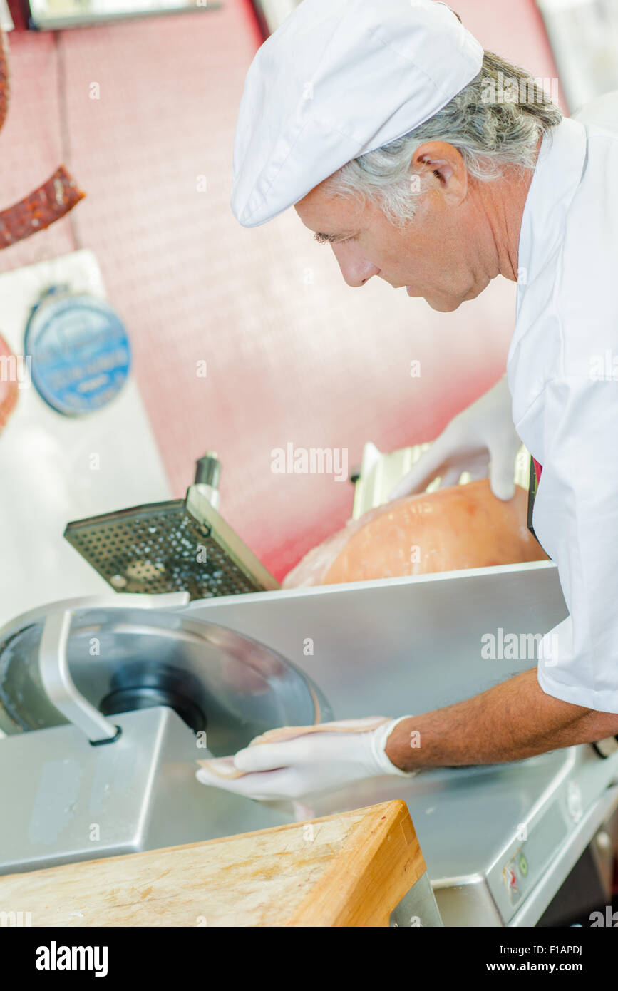 Man using meat slicing machine Stock Photo - Alamy