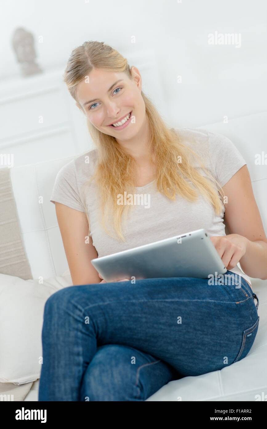 Woman sat on sofa with tablet computer Stock Photo - Alamy