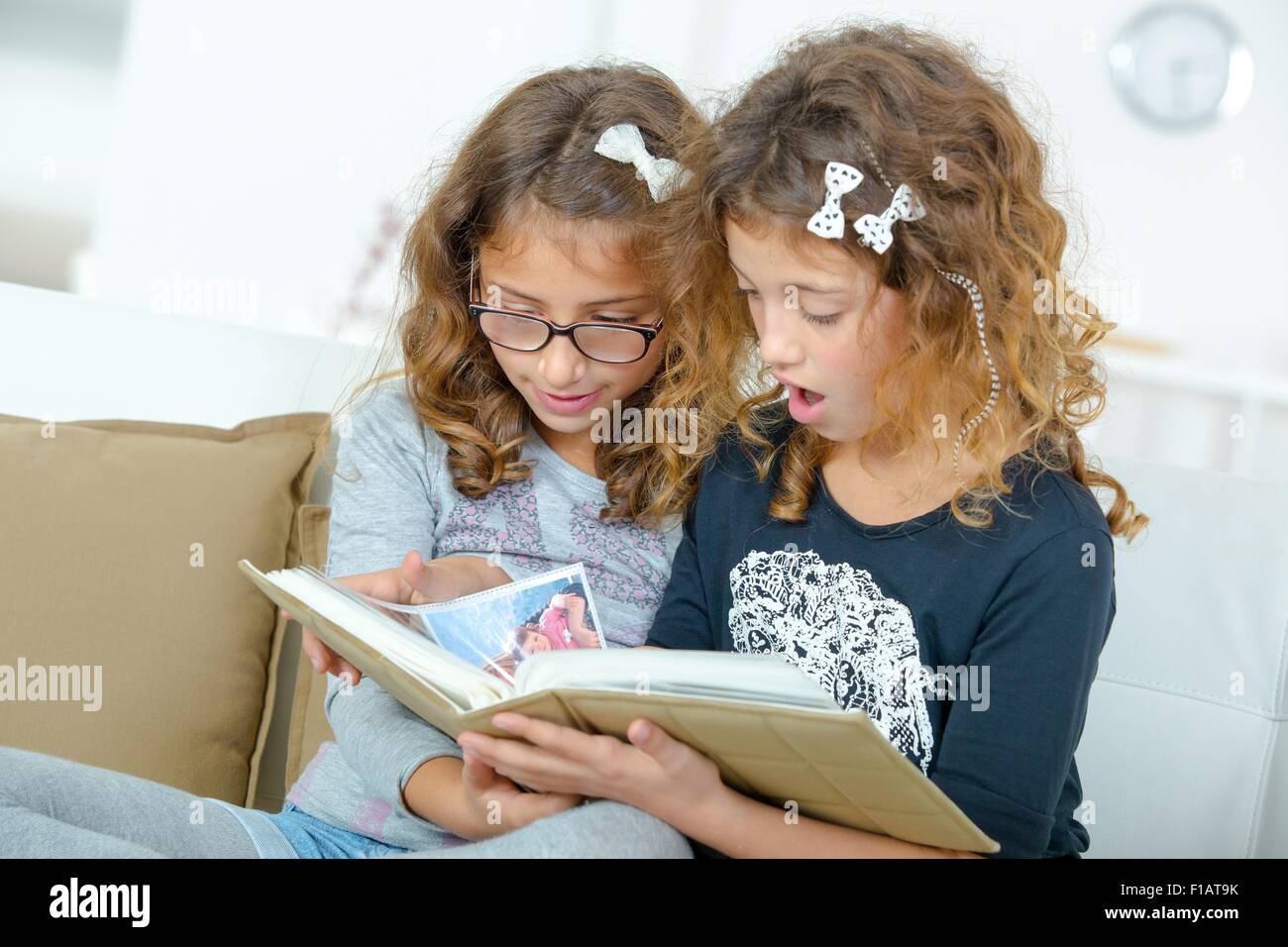 Two sisters reading a book Stock Photo - Alamy
