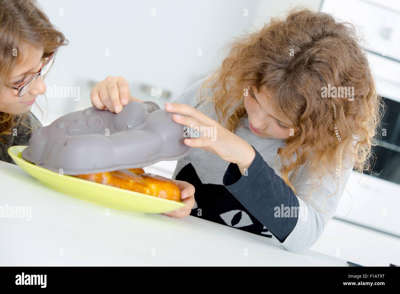 Two little girls have baked a cake Stock Photo - Alamy