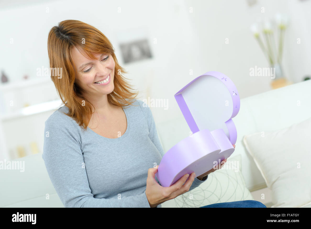 Woman opening a present Stock Photo - Alamy