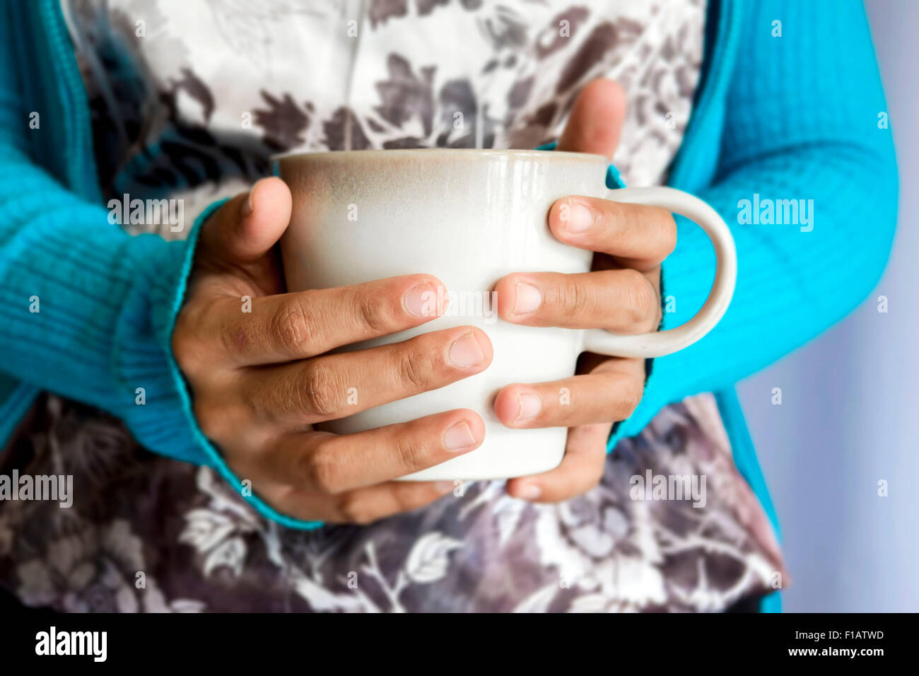 Hand holding on to a mug Stock Photo - Alamy