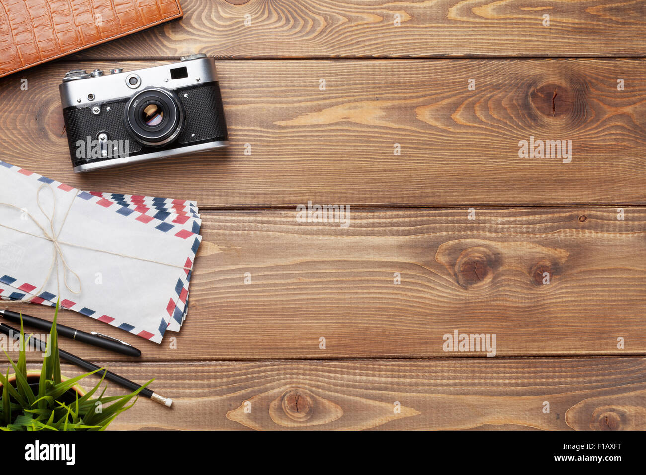 Camera and supplies on office wooden desk table. Top view with copy ...
