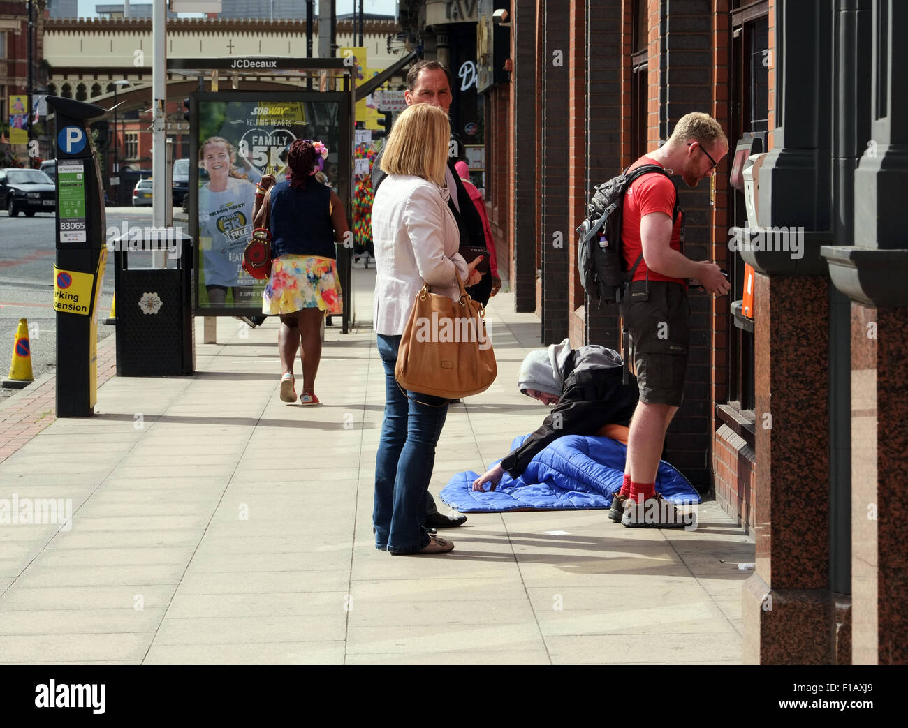 Homeless man sat at the side of a cash point on the streets of ...