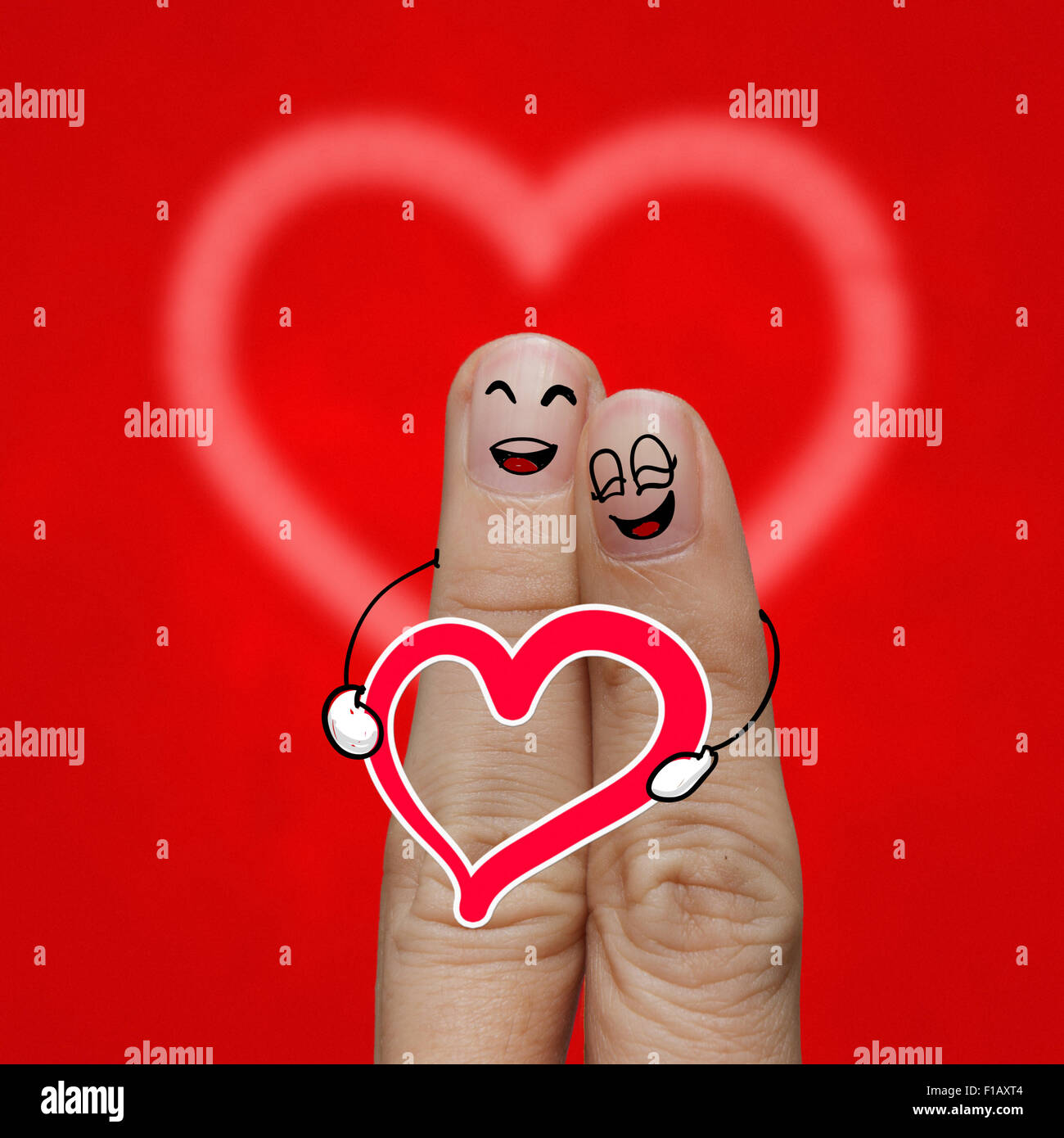 the happy finger couple in love with painted smiley and hold heart ...