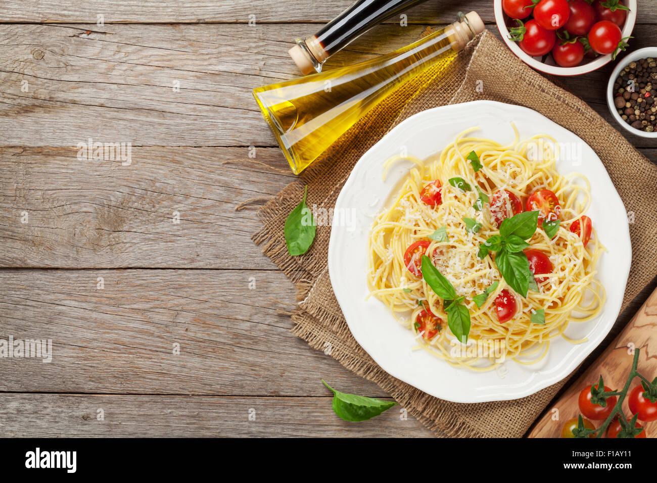 Spaghetti pasta with tomatoes and parsley on wooden table. Top view ...