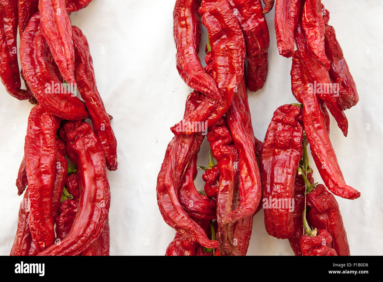 A string of red peppers drying in the sun Stock Photo - Alamy