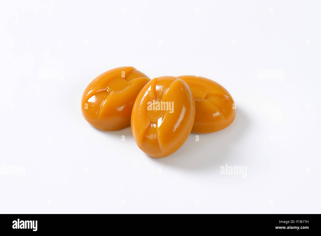 three caramel candies on white background Stock Photo - Alamy
