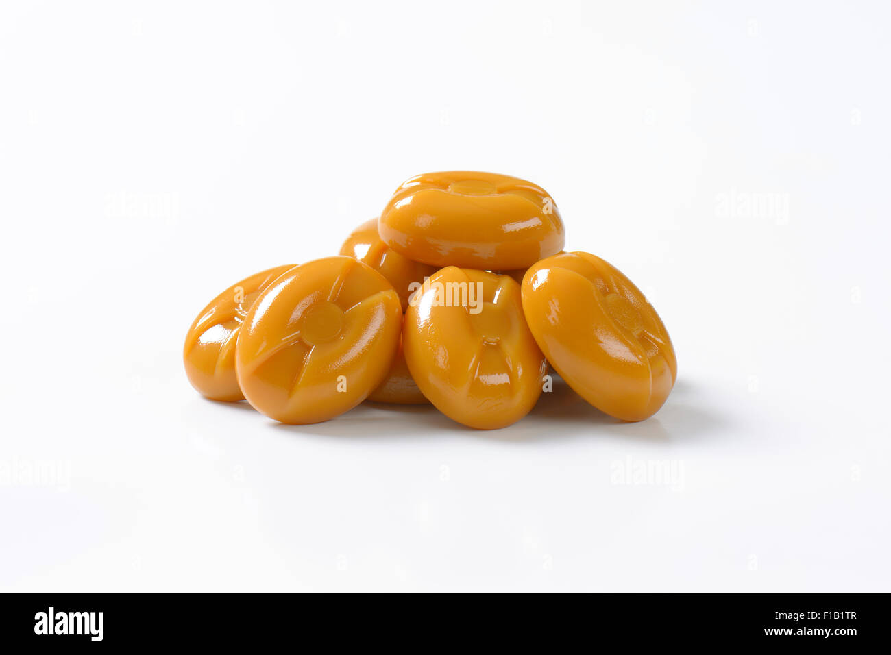 handful of caramel candies on white background Stock Photo - Alamy