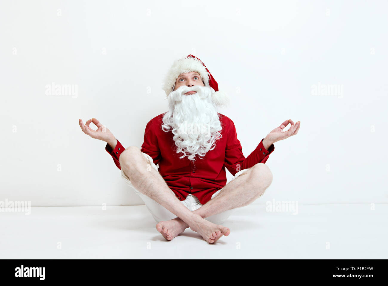 santa in summer cloth meditate near white wall, concept of breaking ...