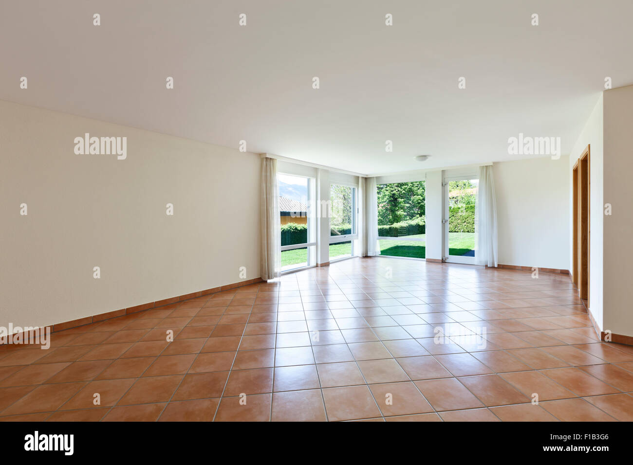 room with terracotta floor, windows overlooking the garden Stock Photo ...
