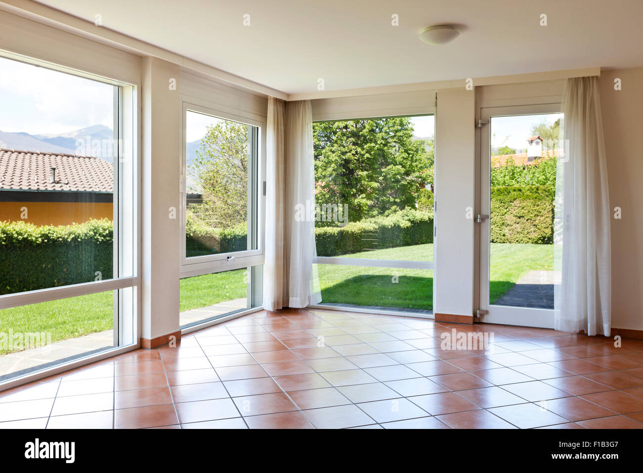 room with terracotta floor, windows overlooking the garden Stock Photo ...