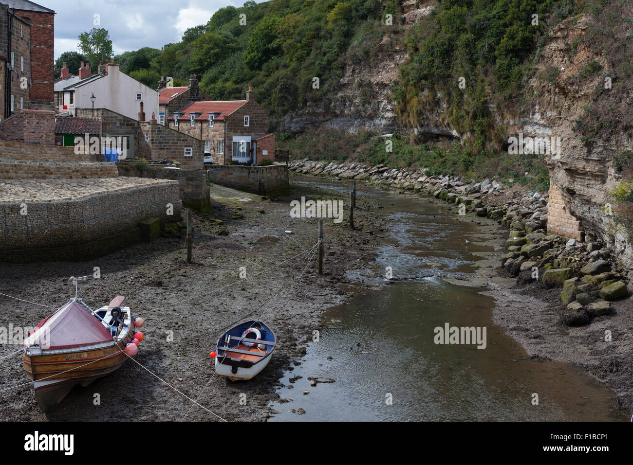 Fishing boats at the tidal mouth of Staithes Beck as it enters Staithes ...