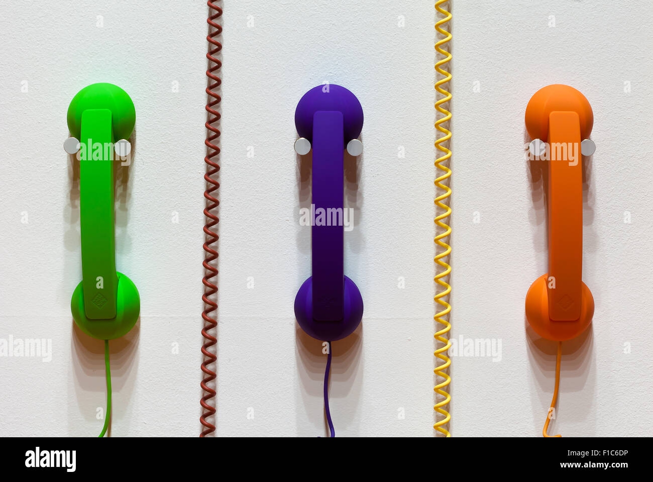 Phones on the wall with phone cords Stock Photo - Alamy