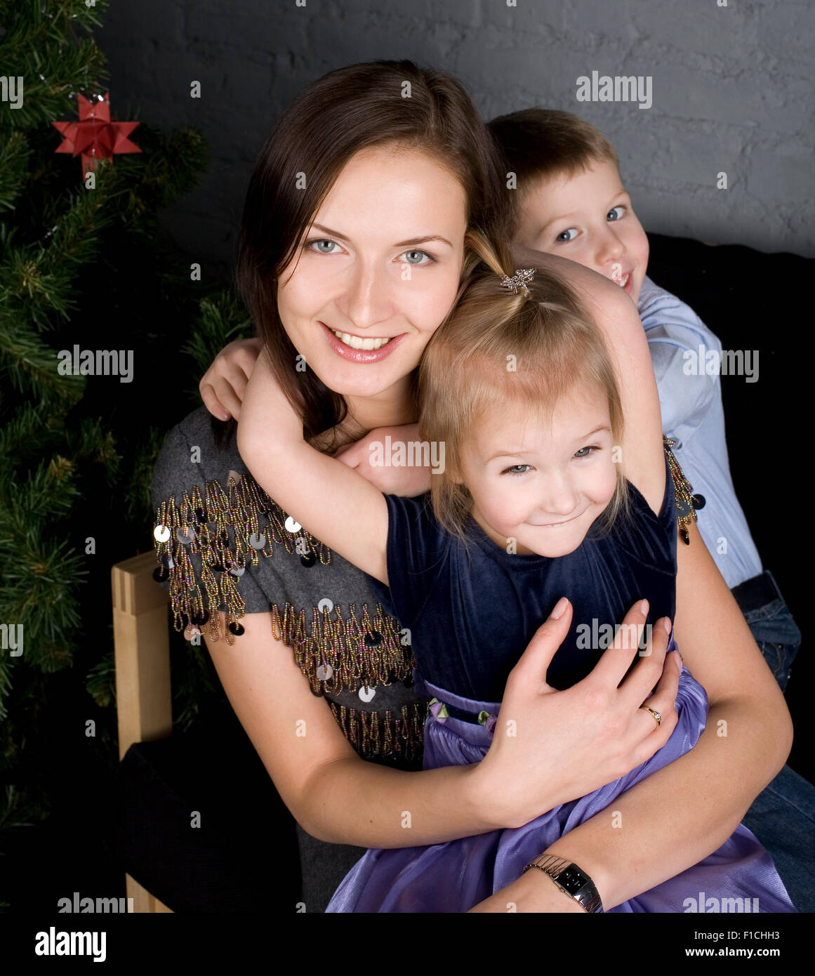 happy family at christmas tree sitting home smiling Stock Photo - Alamy