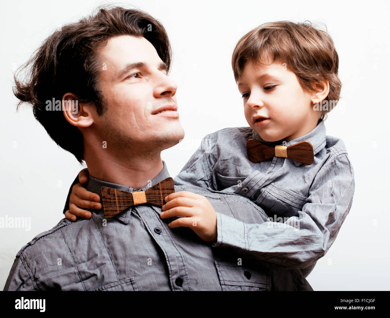 father with son in bowties on white background, casual look family ...