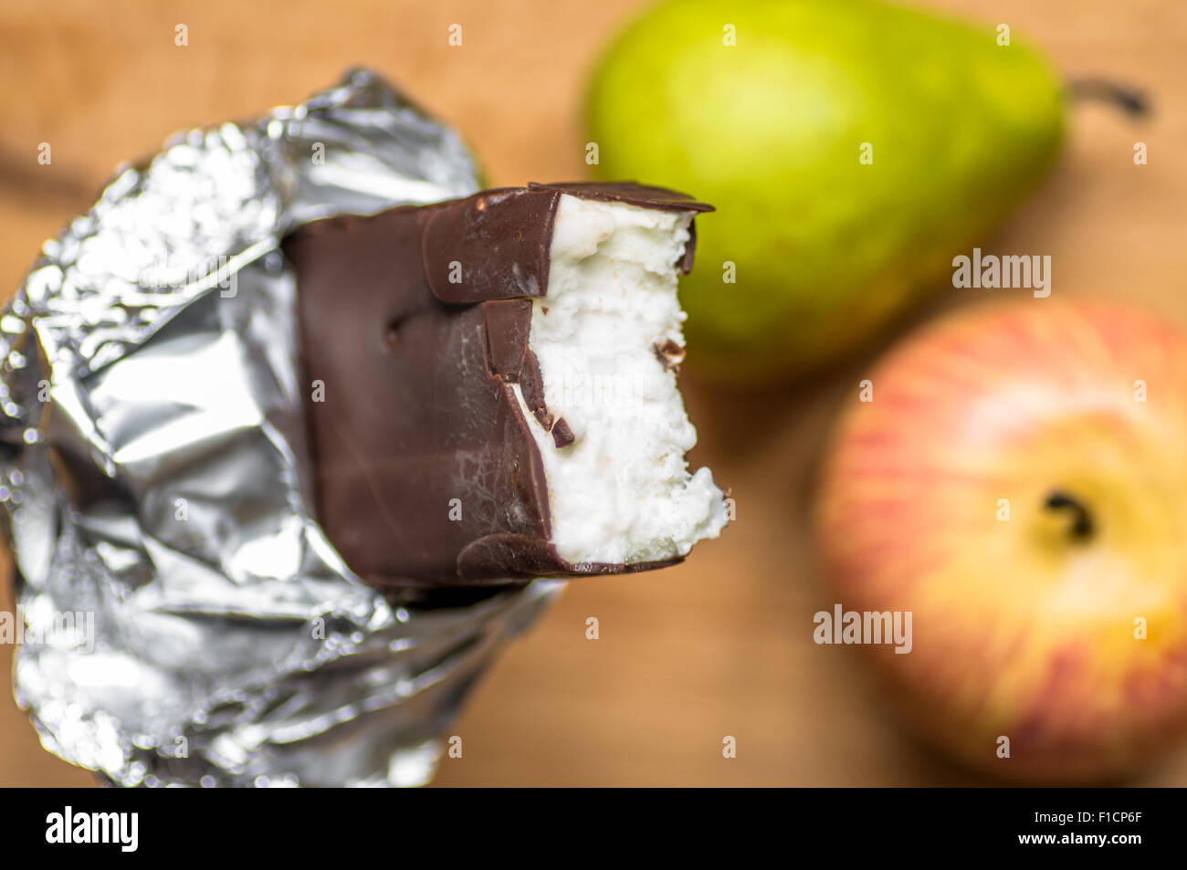 Bitten popsicle in foil wrapper on a background of fruits Stock Photo ...