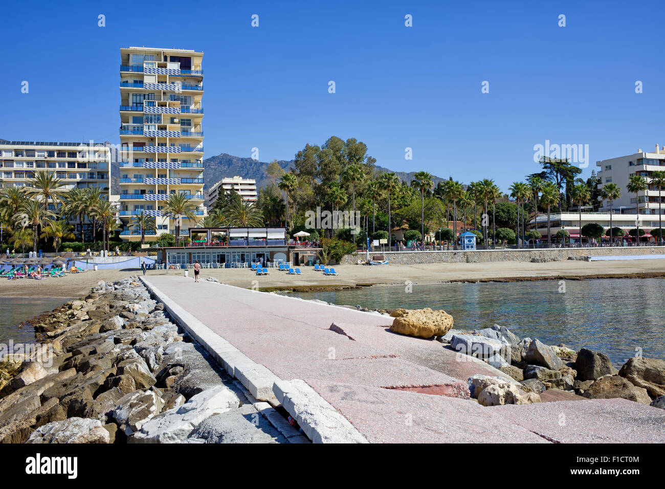 Pier, beach and apartment buildings in resort town of Marbella on Costa ...