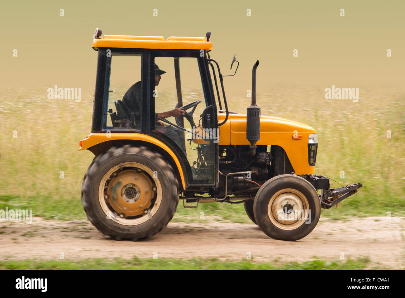Farm tractor goes on road Stock Photo - Alamy