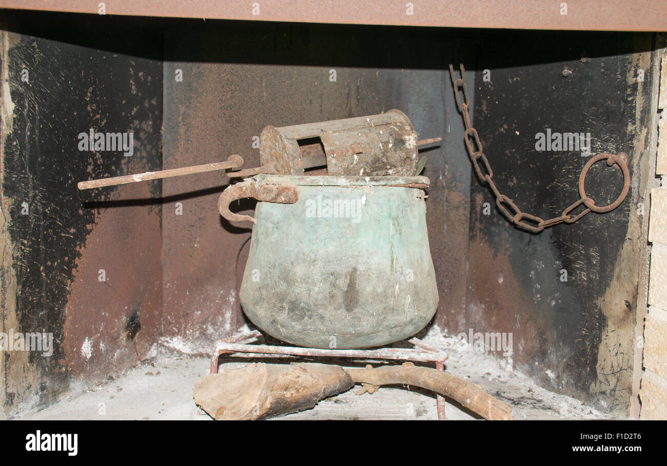 Old fireplace of a country house, inside an old copper pot with old ...