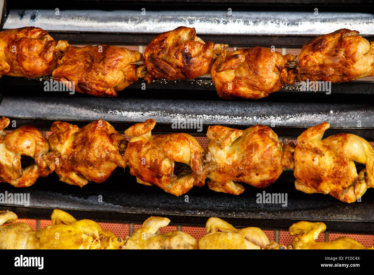 Roasted chicken in a row turning at industrial roaster Stock Photo - Alamy